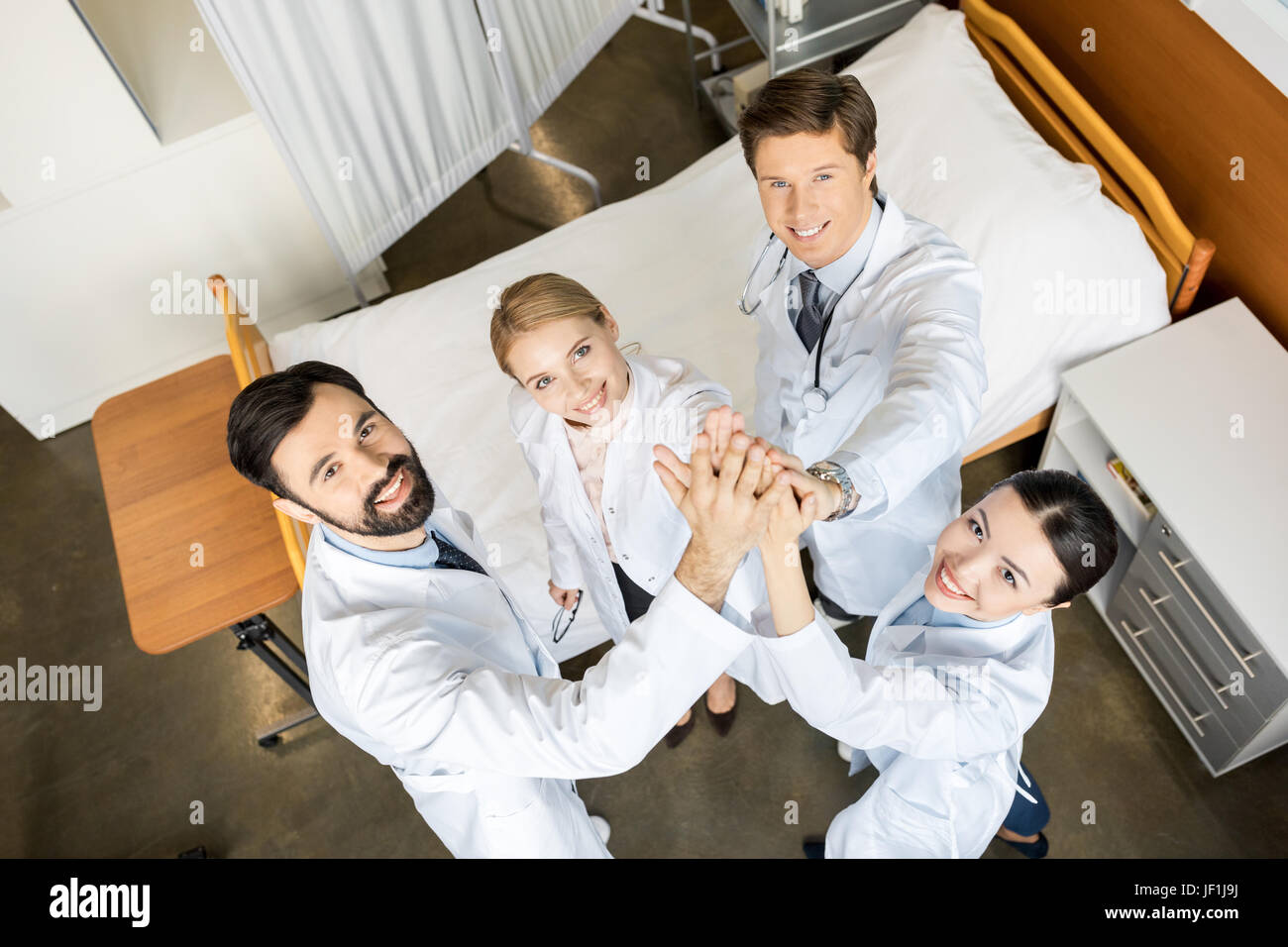 Group of professional young doctors holding hands together in hospital ...