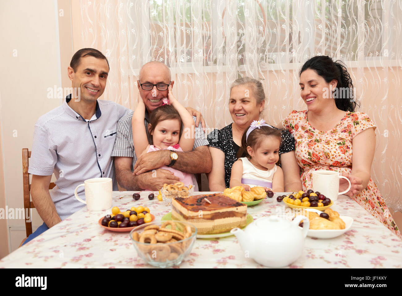 big family drinking tea in dining room Stock Photo - Alamy