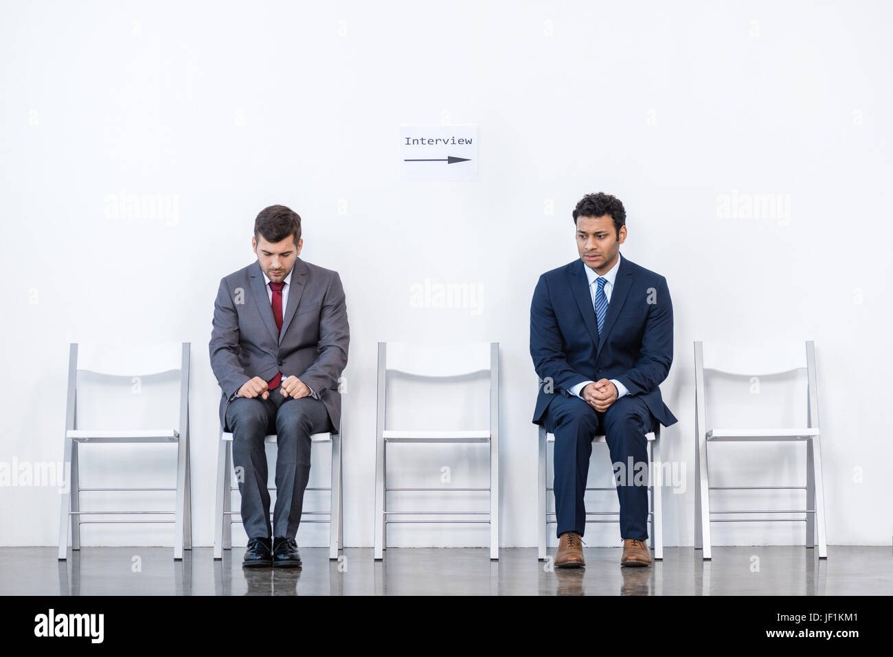 businessmen in suits sitting on chairs at white waiting room. business ...