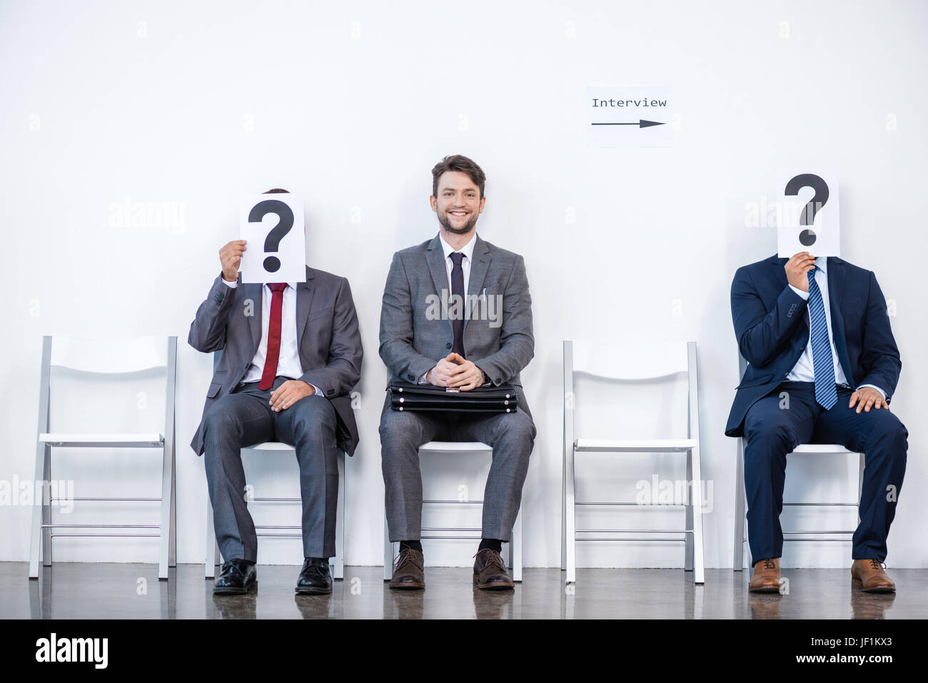 businesspeople sitting in queue and waiting for interview, holding ...