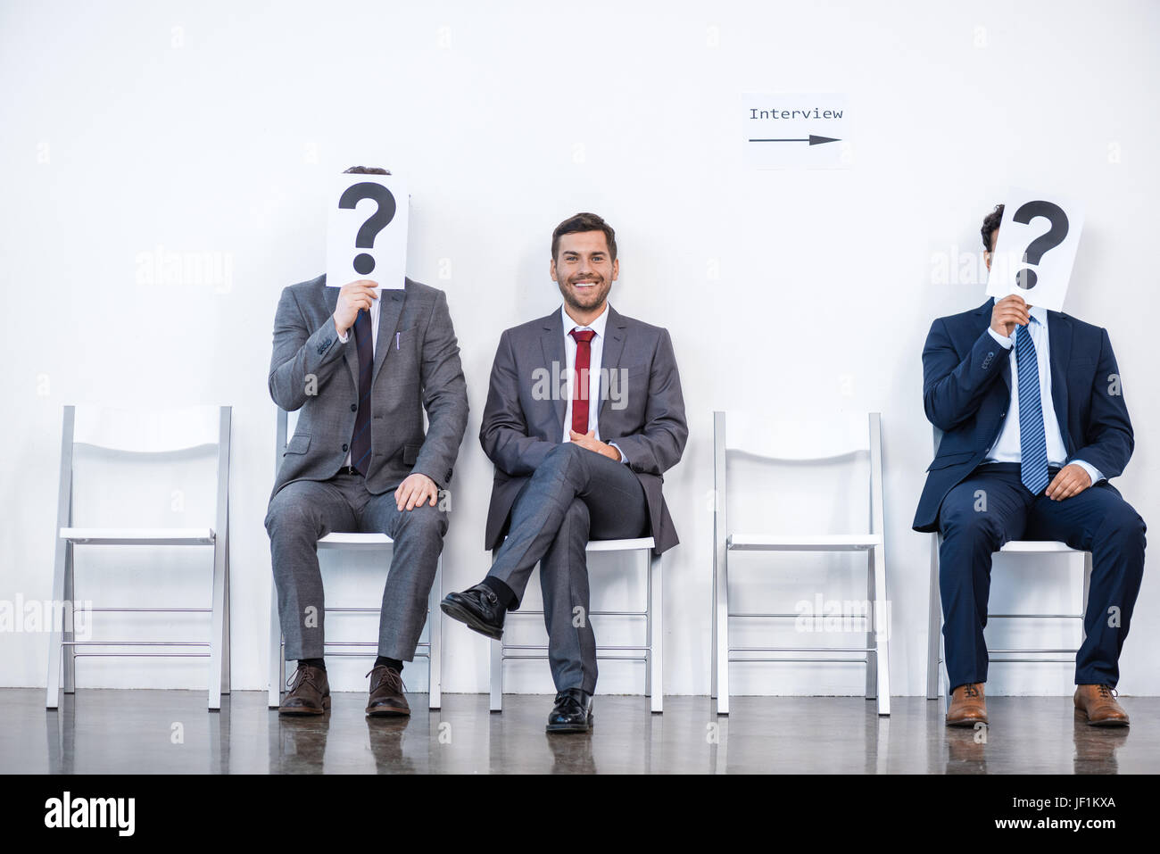 businesspeople sitting in queue and waiting for interview, holding ...
