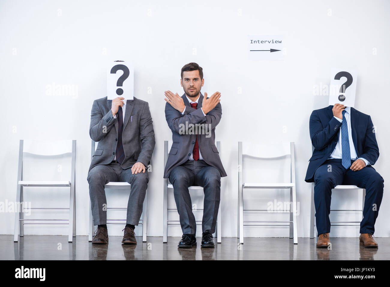businesspeople sitting in queue and waiting for interview, holding ...