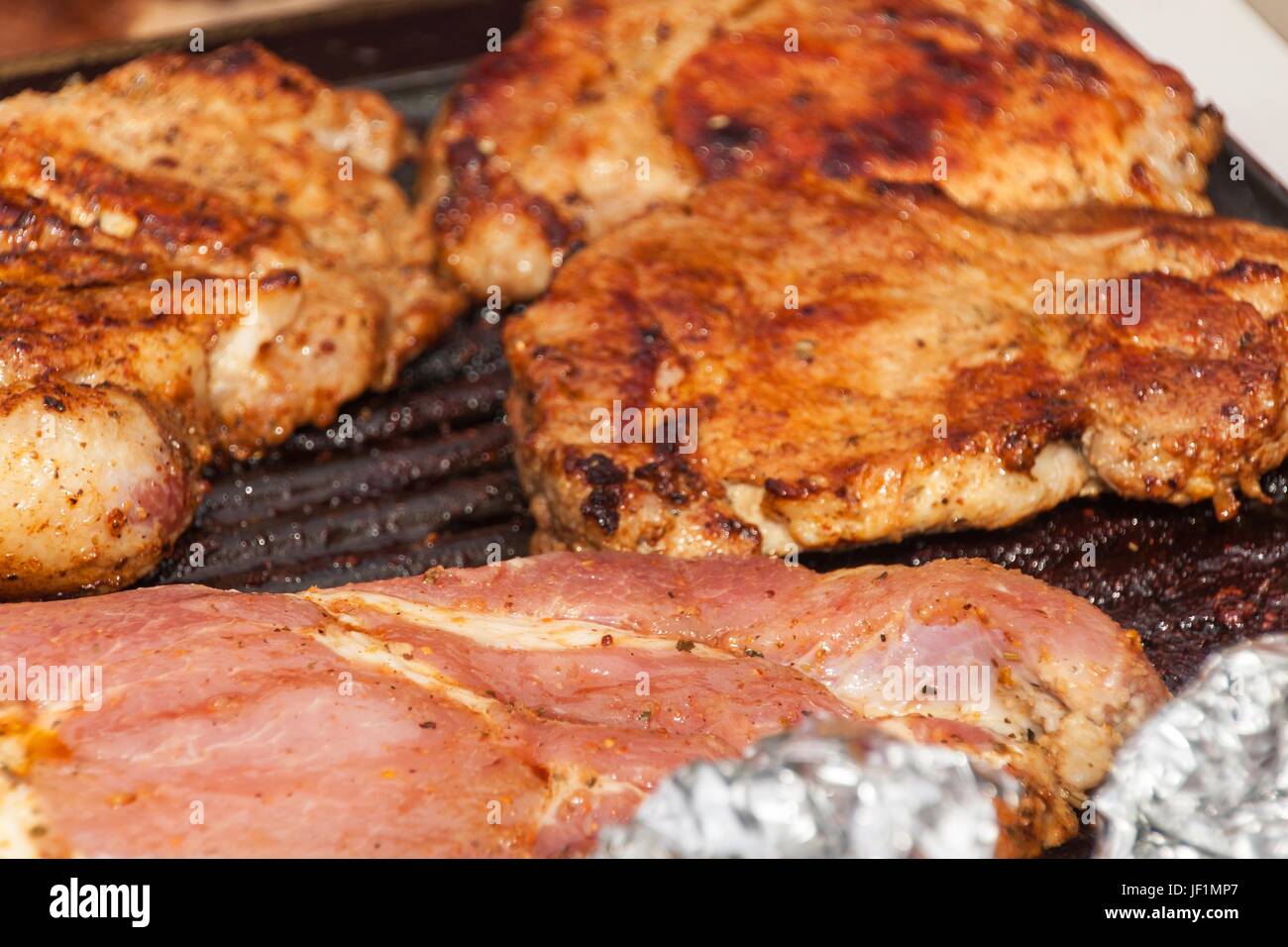 Chicken and pork on electric grill. Summer barbecue. Close-up view ...