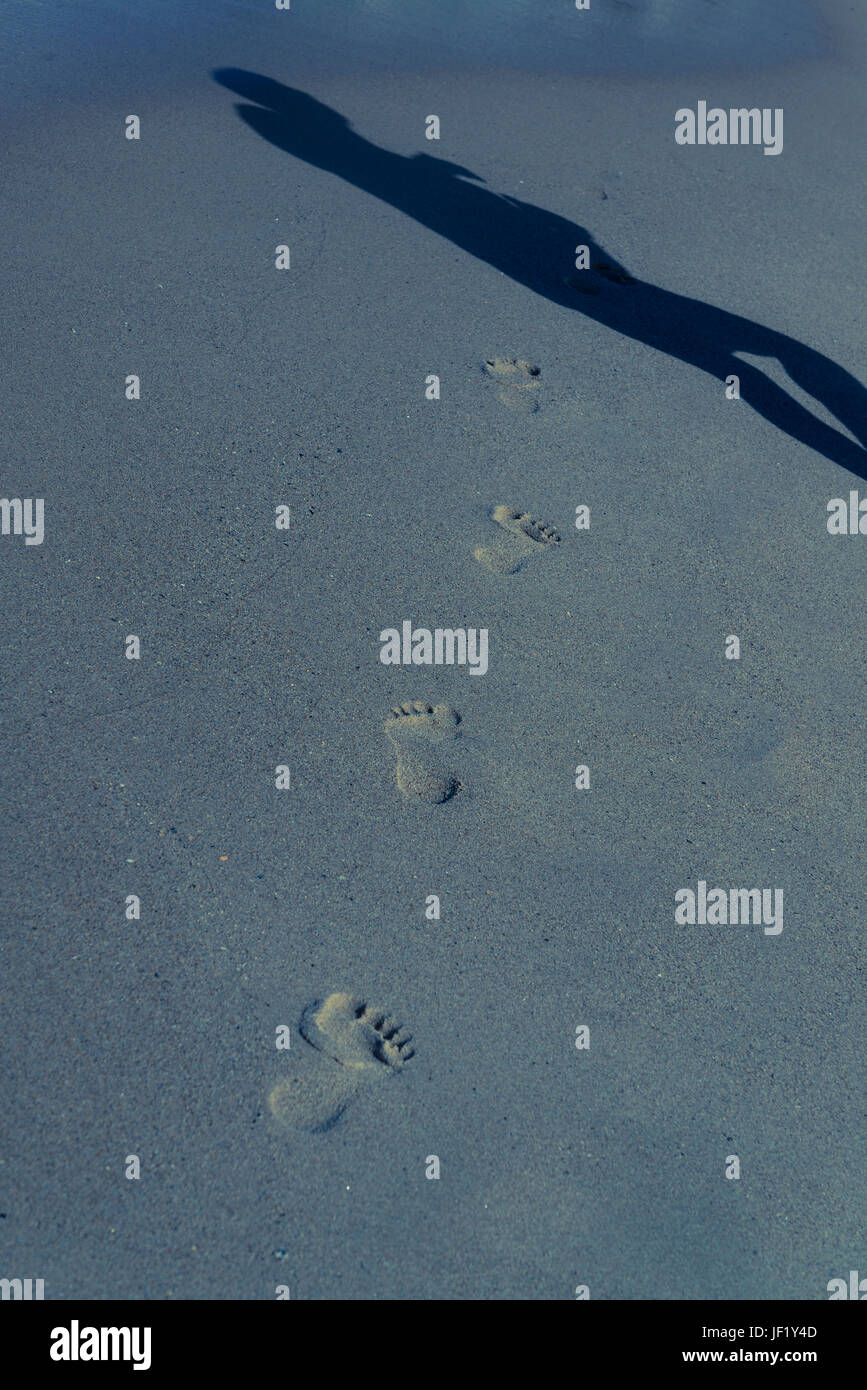 Footprints in sand and shadow of a human figure, Sydney, NSW, Australia ...