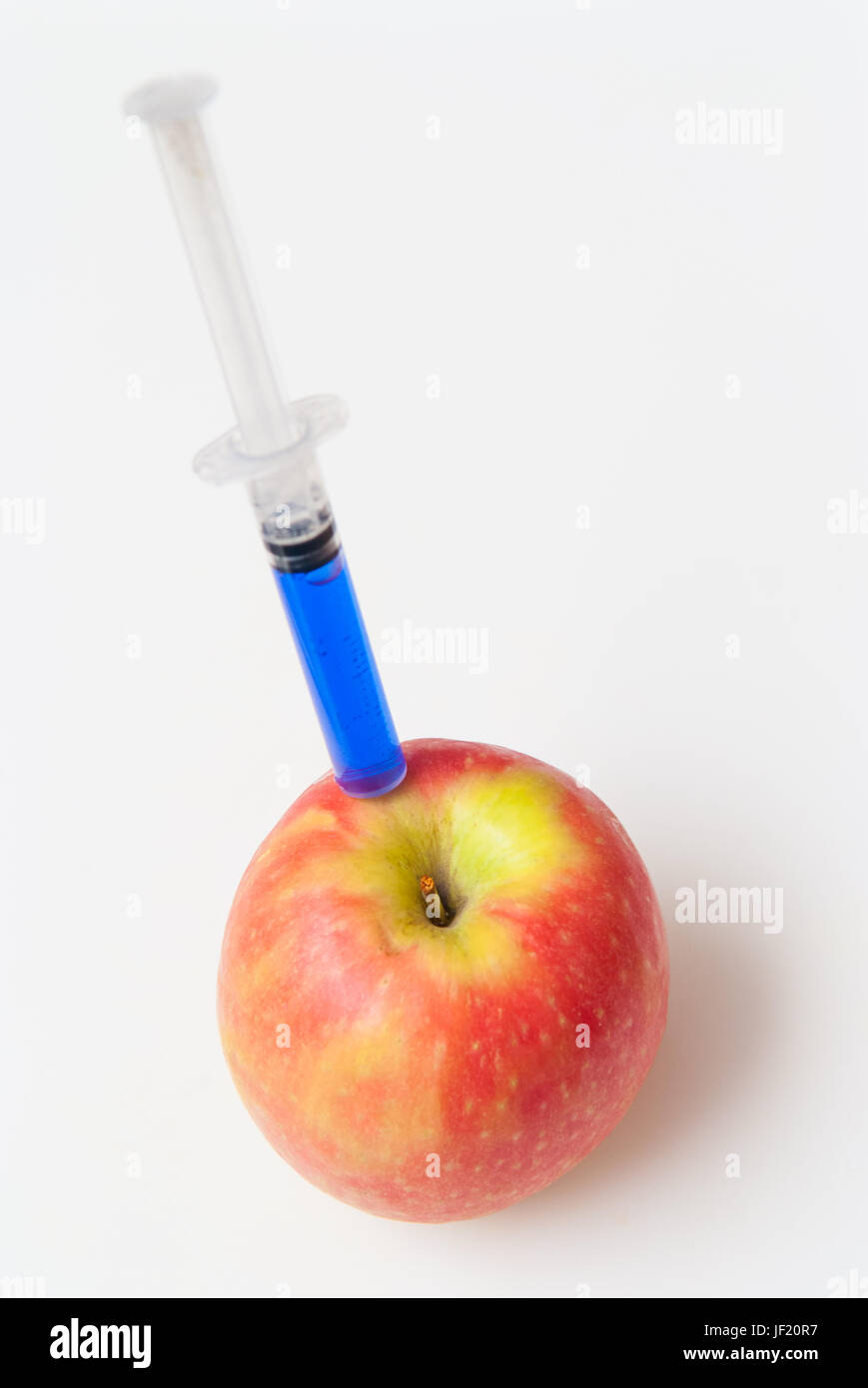 Gm food concept, additives and chemicals being injected into fruit ...