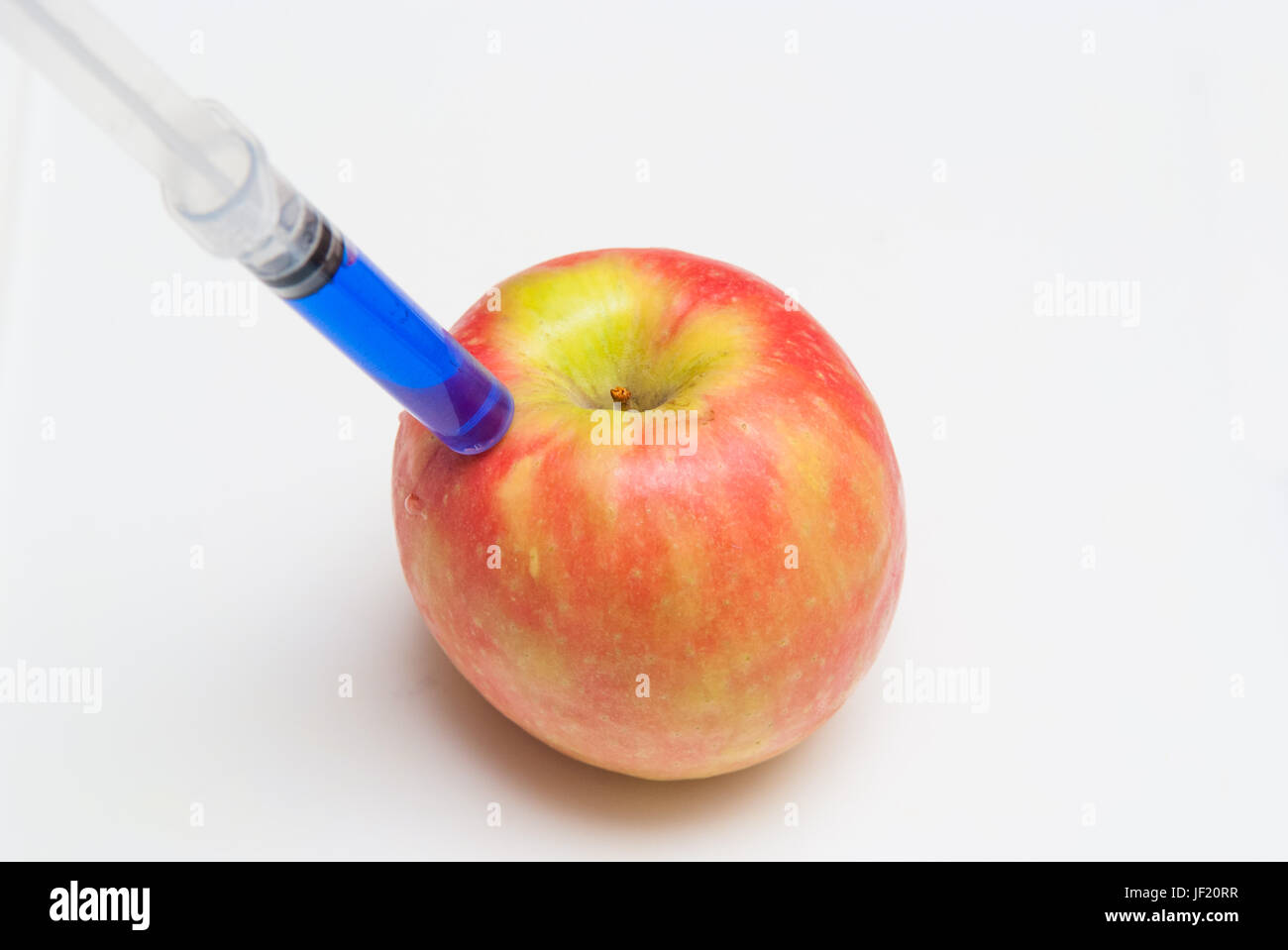 Gm food concept, additives and chemicals being injected into fruit ...