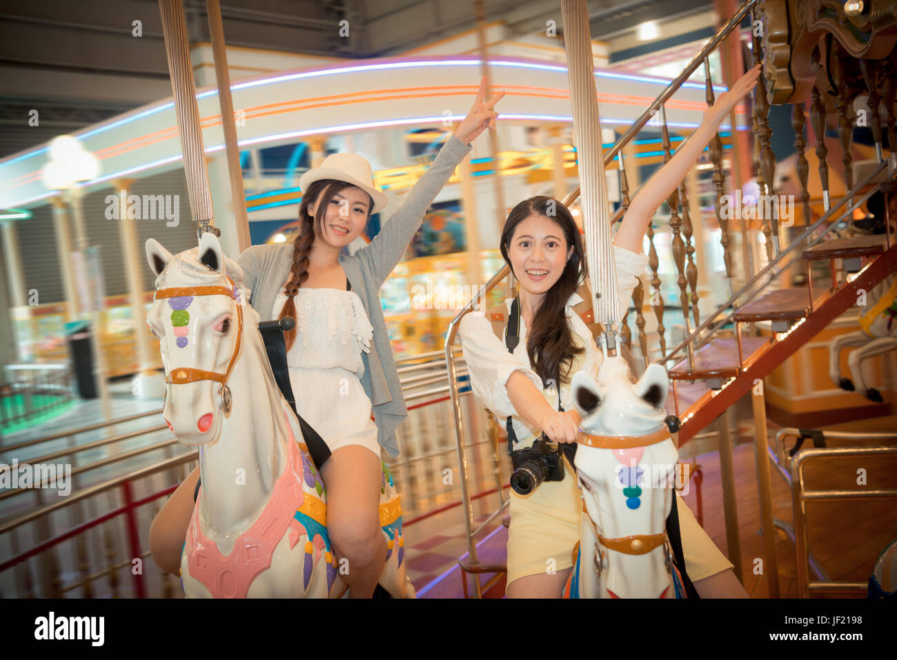 happy women riding carousel horses equipment in the popular amusement ...