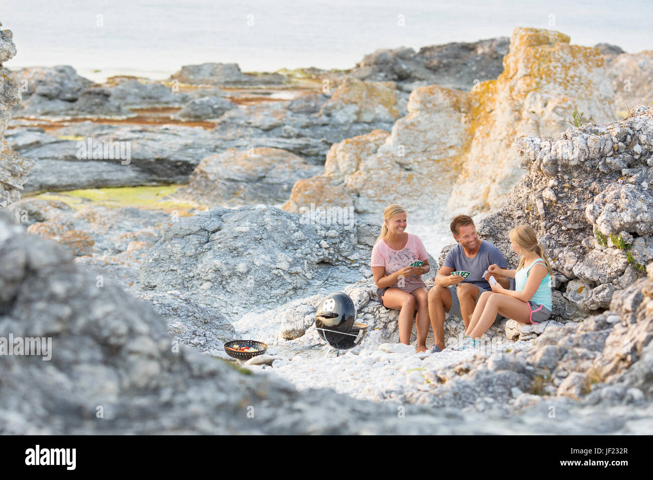 Family playing cards on rocks Stock Photo - Alamy