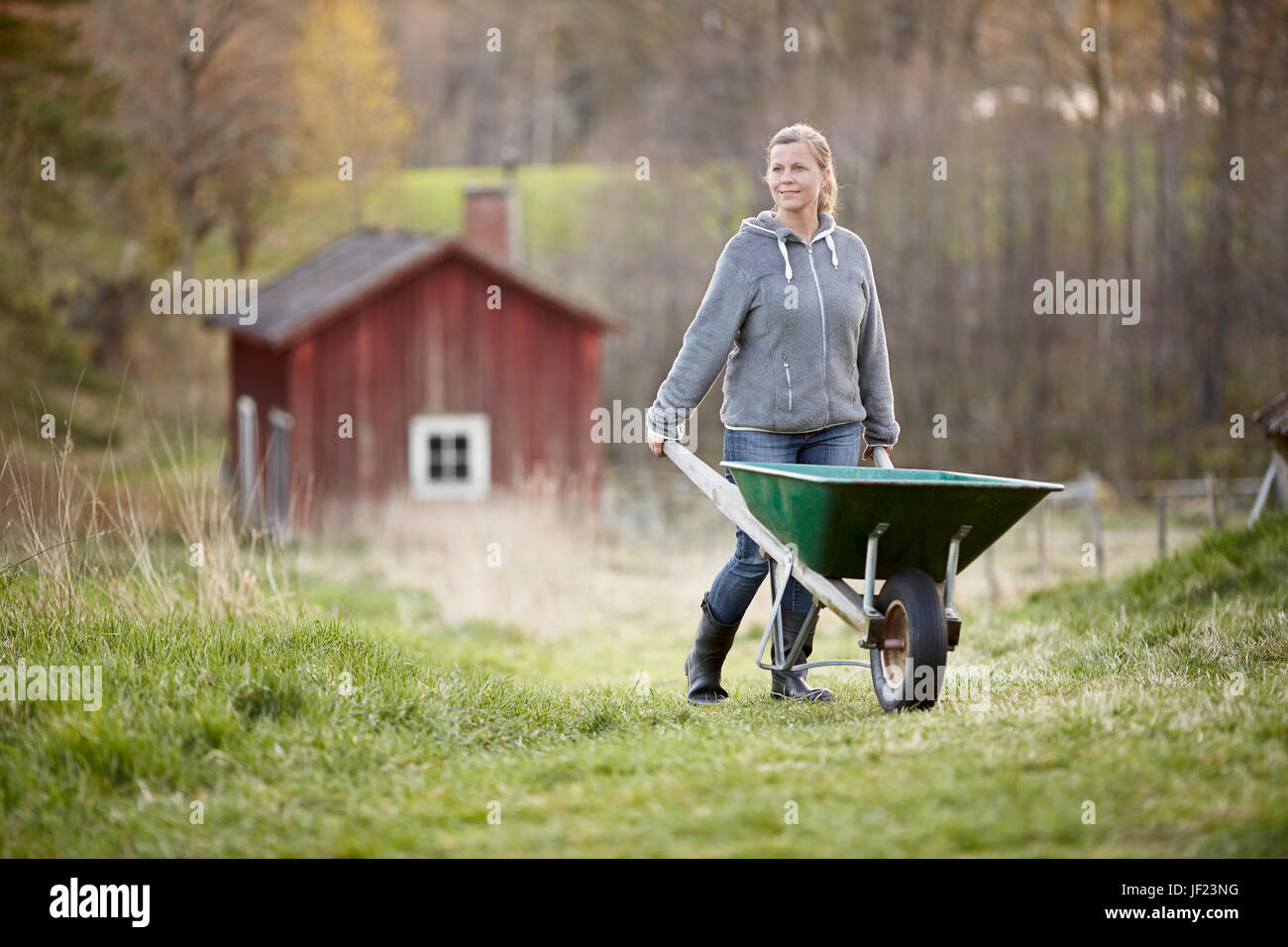 Woman with wheelbarrow Stock Photo - Alamy