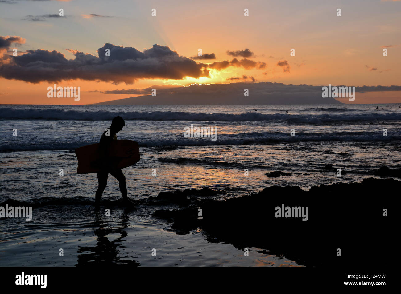 Surfer at sunset on a calm ocean Stock Photo - Alamy