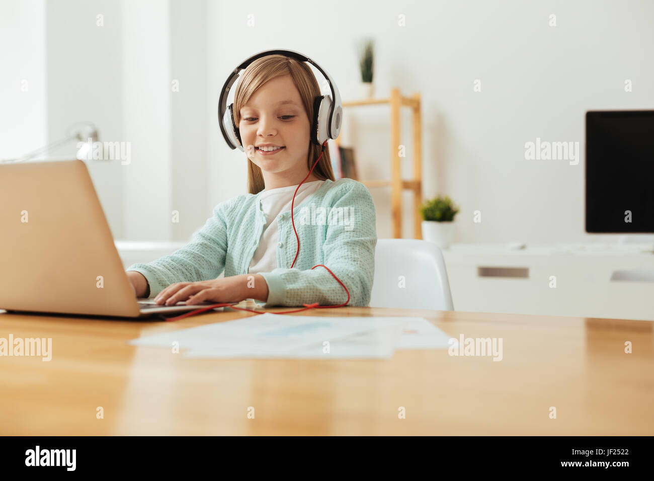 Inspired lively girl listening to music while studying Stock Photo - Alamy