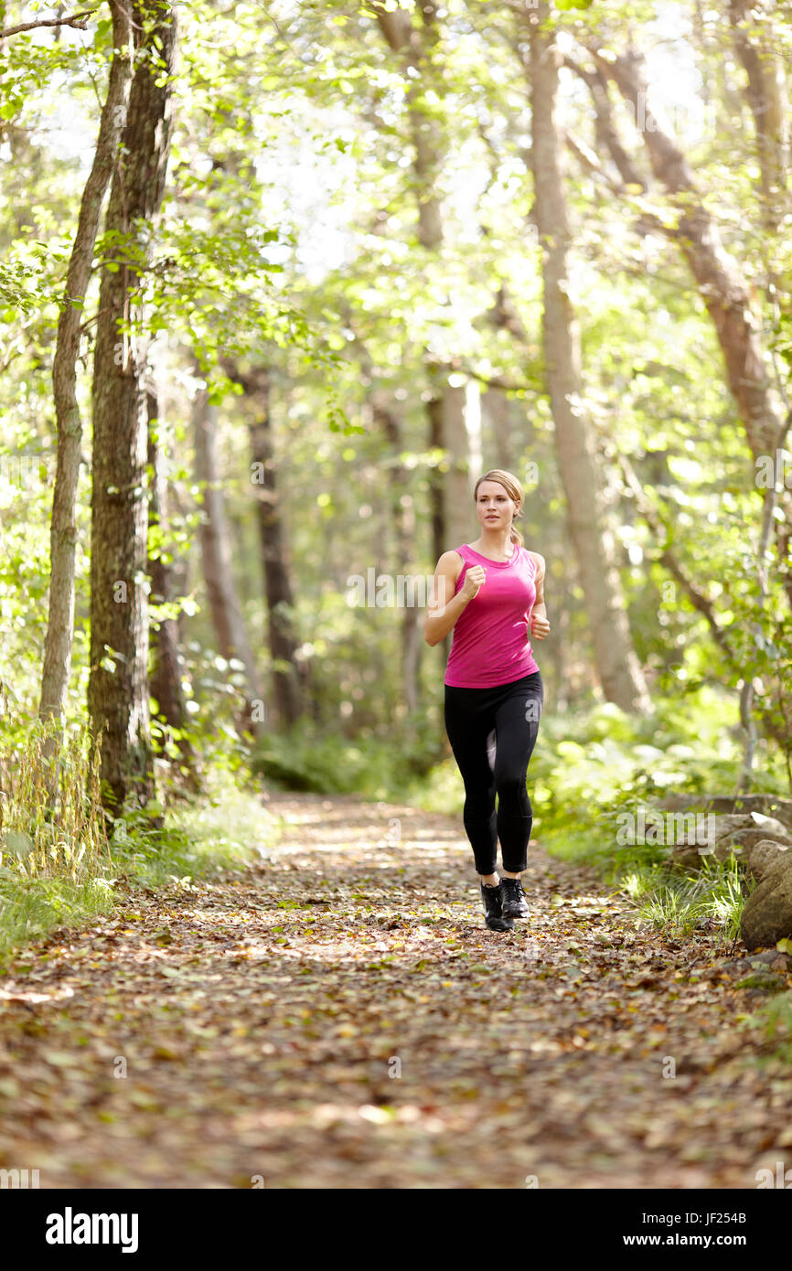 Woman jogging in forest Stock Photo - Alamy