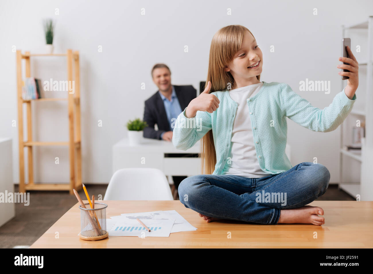 Beautiful sociable girl taking a picture of herself Stock Photo - Alamy