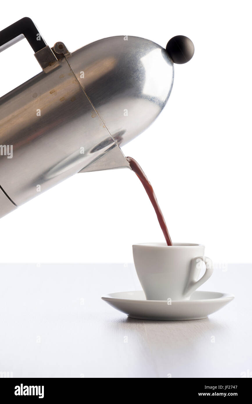 pouring coffee from coffeepot into white coffee cup, on white table ...