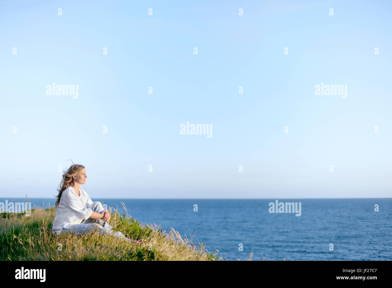 Woman relaxing at sea Stock Photo - Alamy