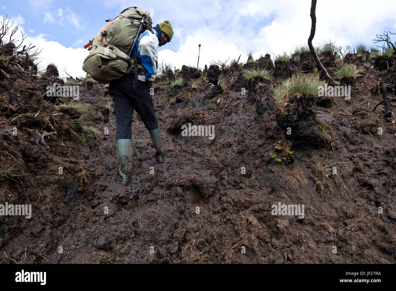 Hiking guide resting along a muddy stretch of trail, Kilembi Route ...