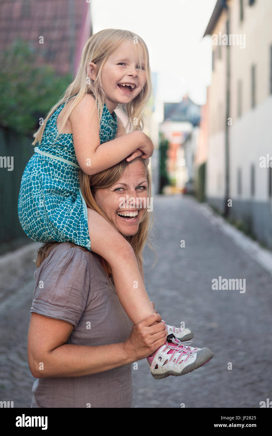 Mother carrying daughter on shoulders Stock Photo - Alamy