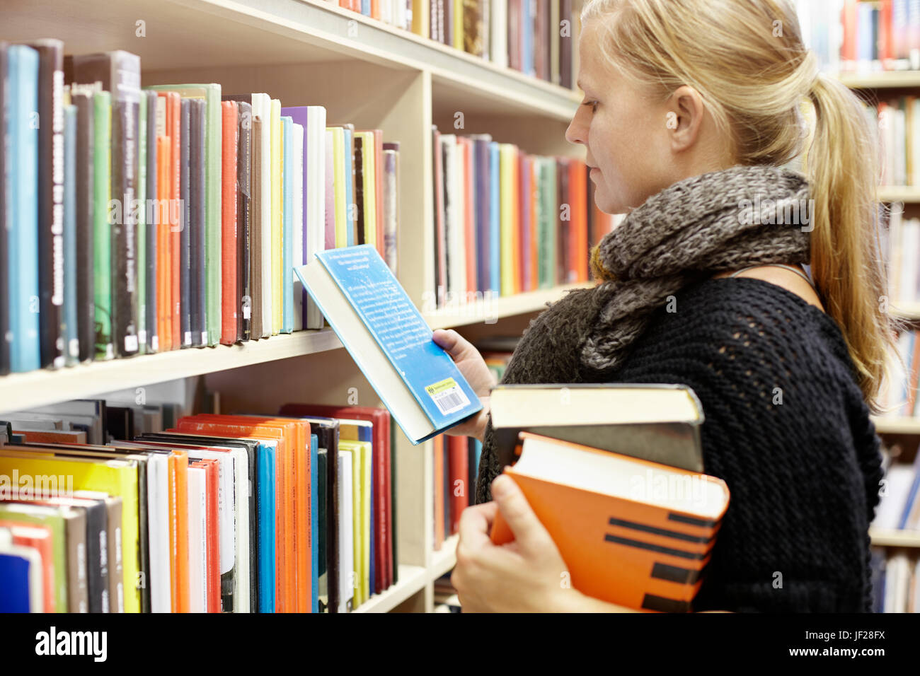 Woman choosing books in library Stock Photo - Alamy