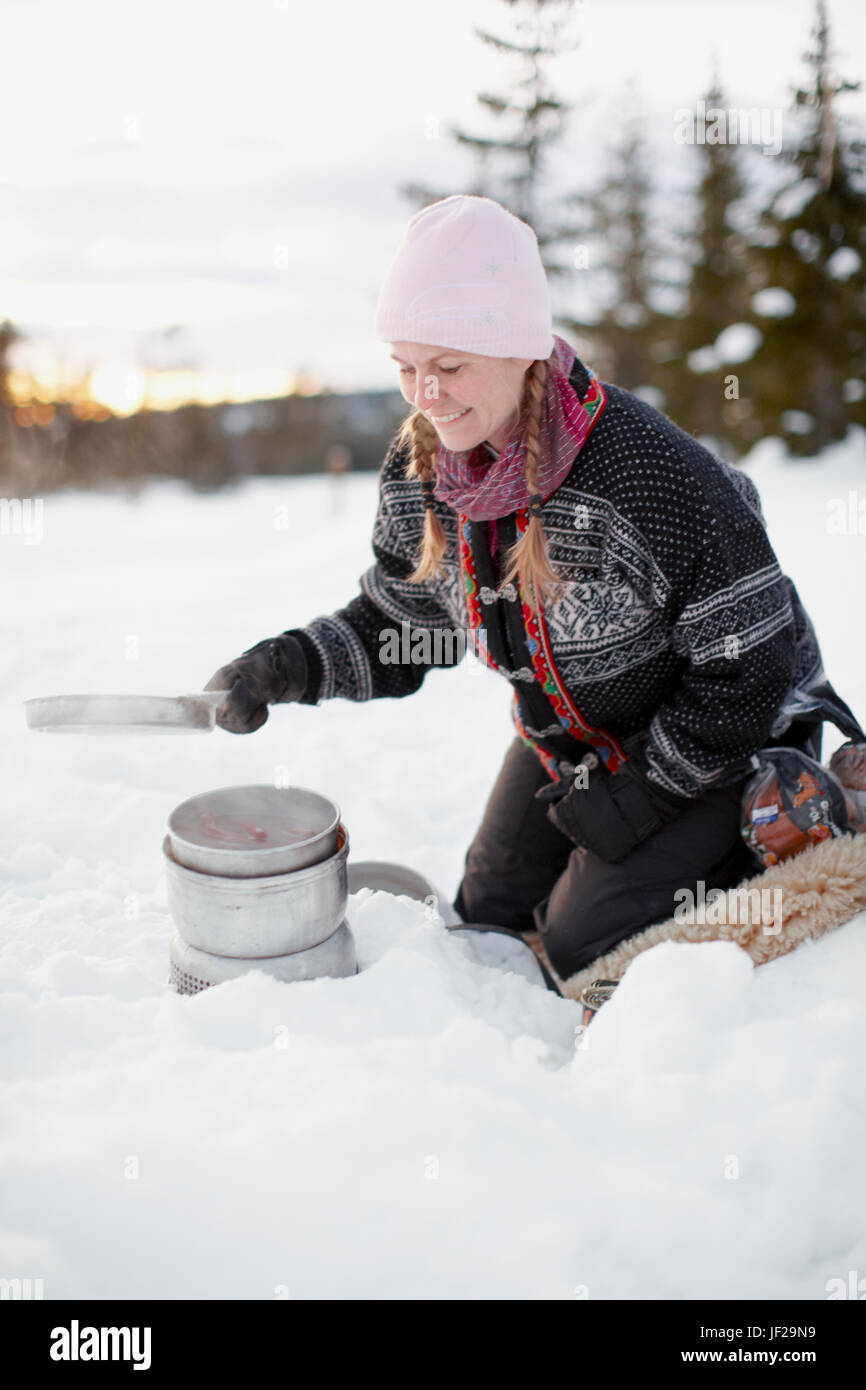 Woman cooking on snow Stock Photo - Alamy