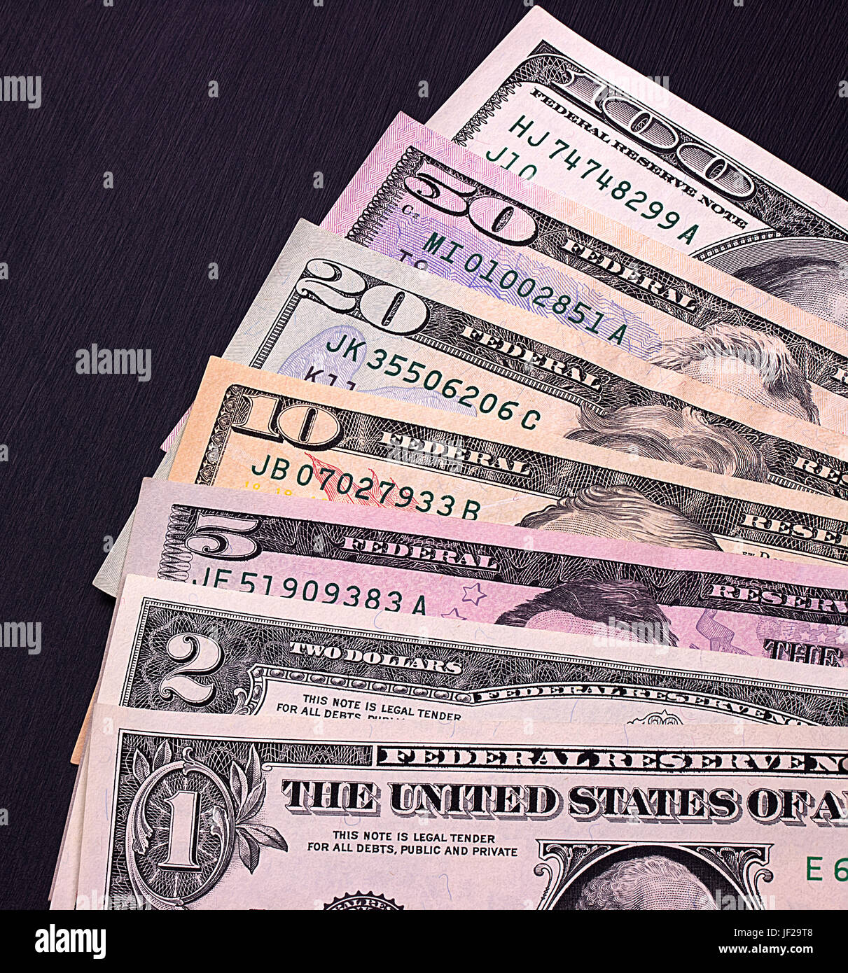 Abstract dollar bills of different denominations on black background ...