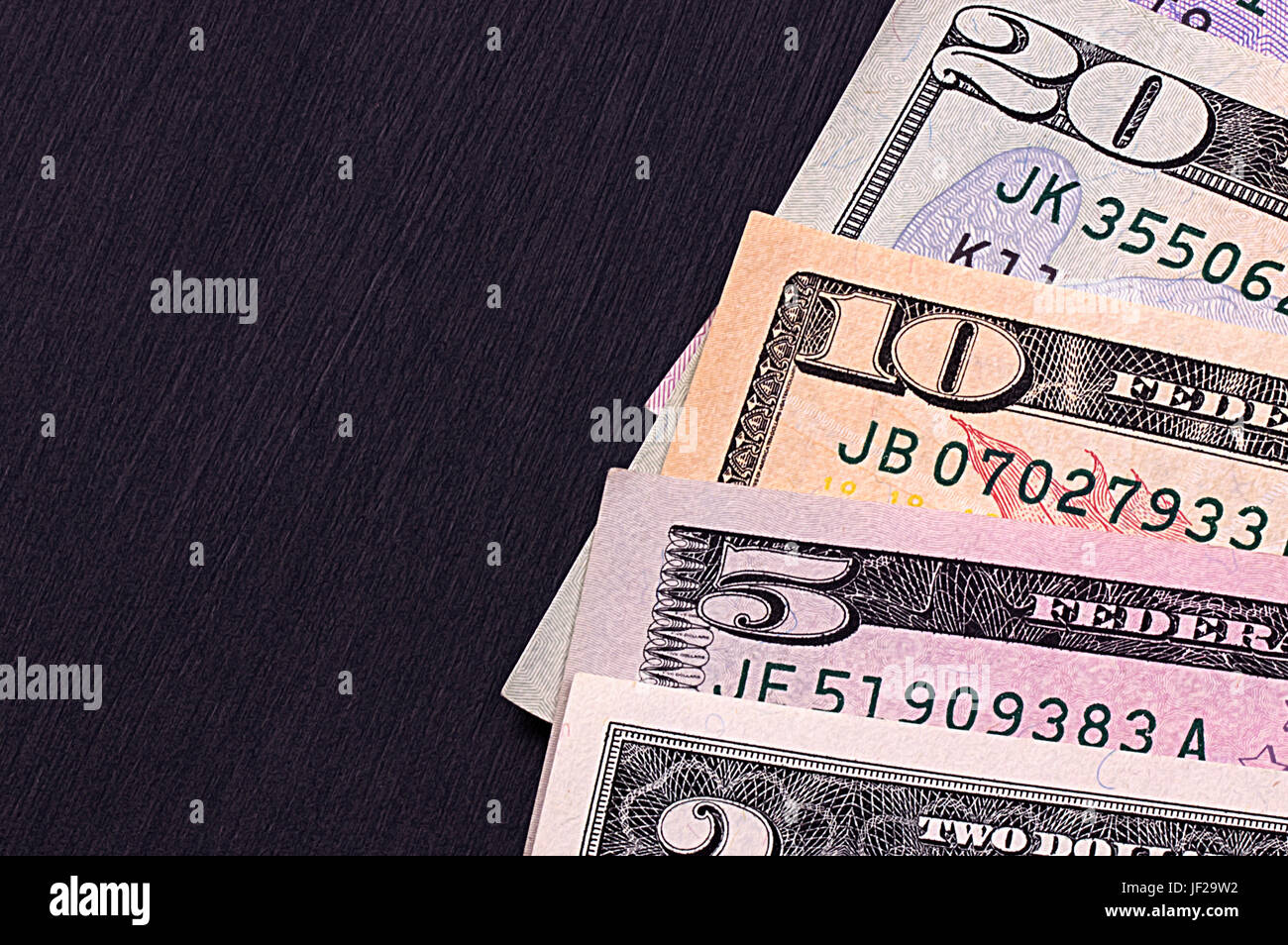 Abstract dollar bills of different denominations on black background ...