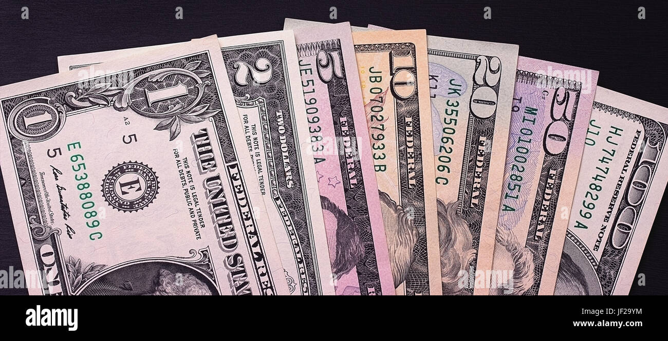 Abstract dollar bills of different denominations on black background ...
