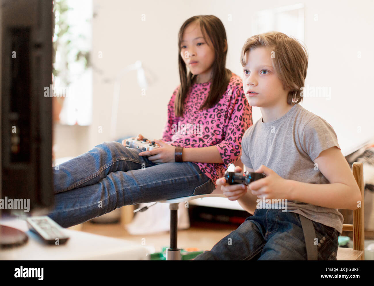 Boy and girl playing video game Stock Photo - Alamy
