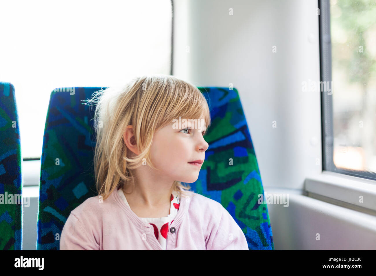 Girl looking through bus window Stock Photo - Alamy