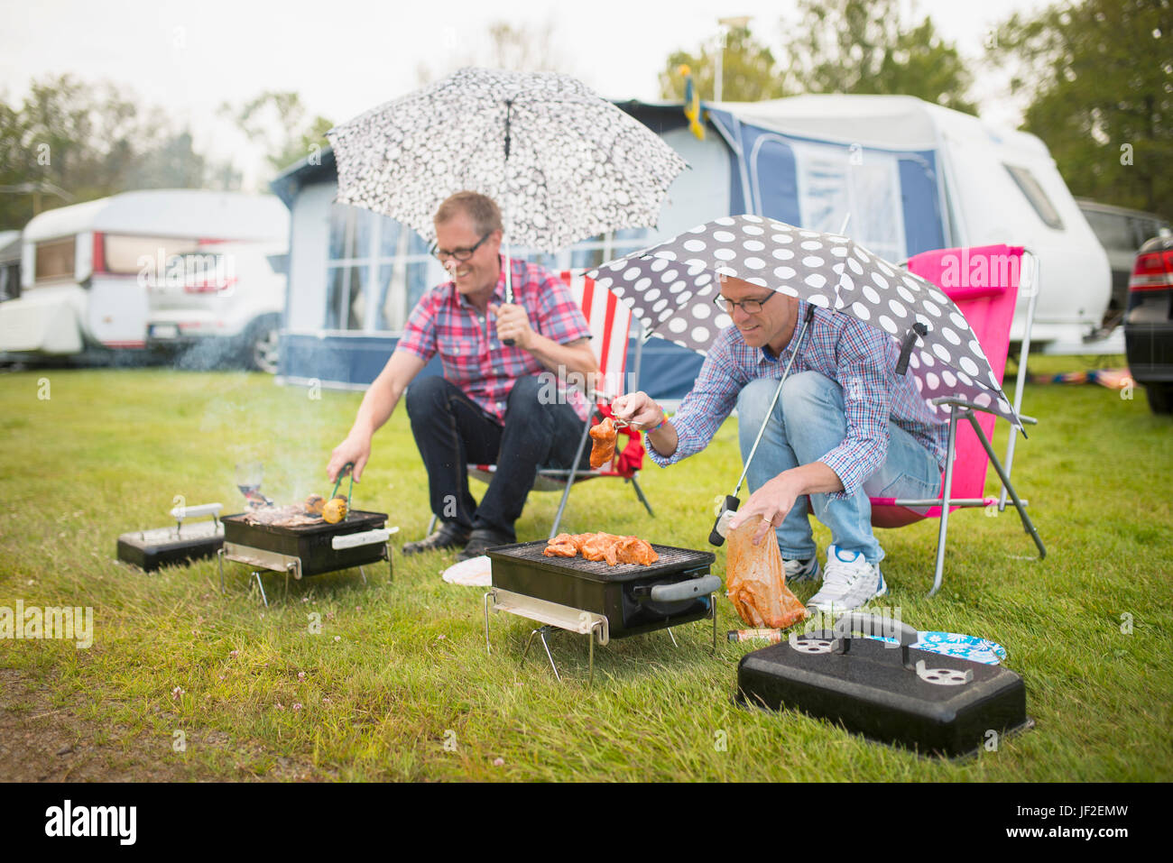 Men barbecuing in rain Stock Photo - Alamy