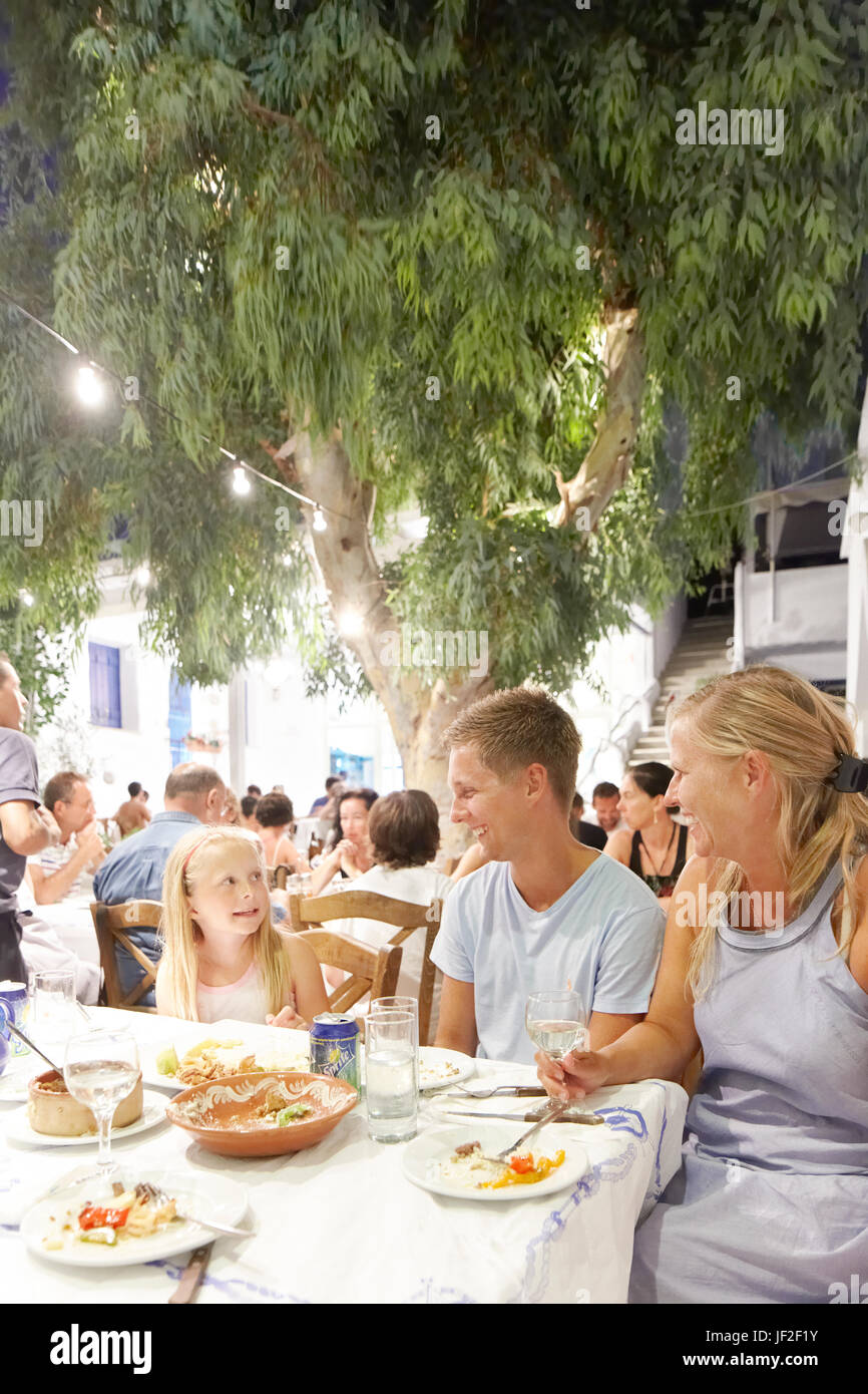Mother with children having dinner in restaurant Stock Photo - Alamy