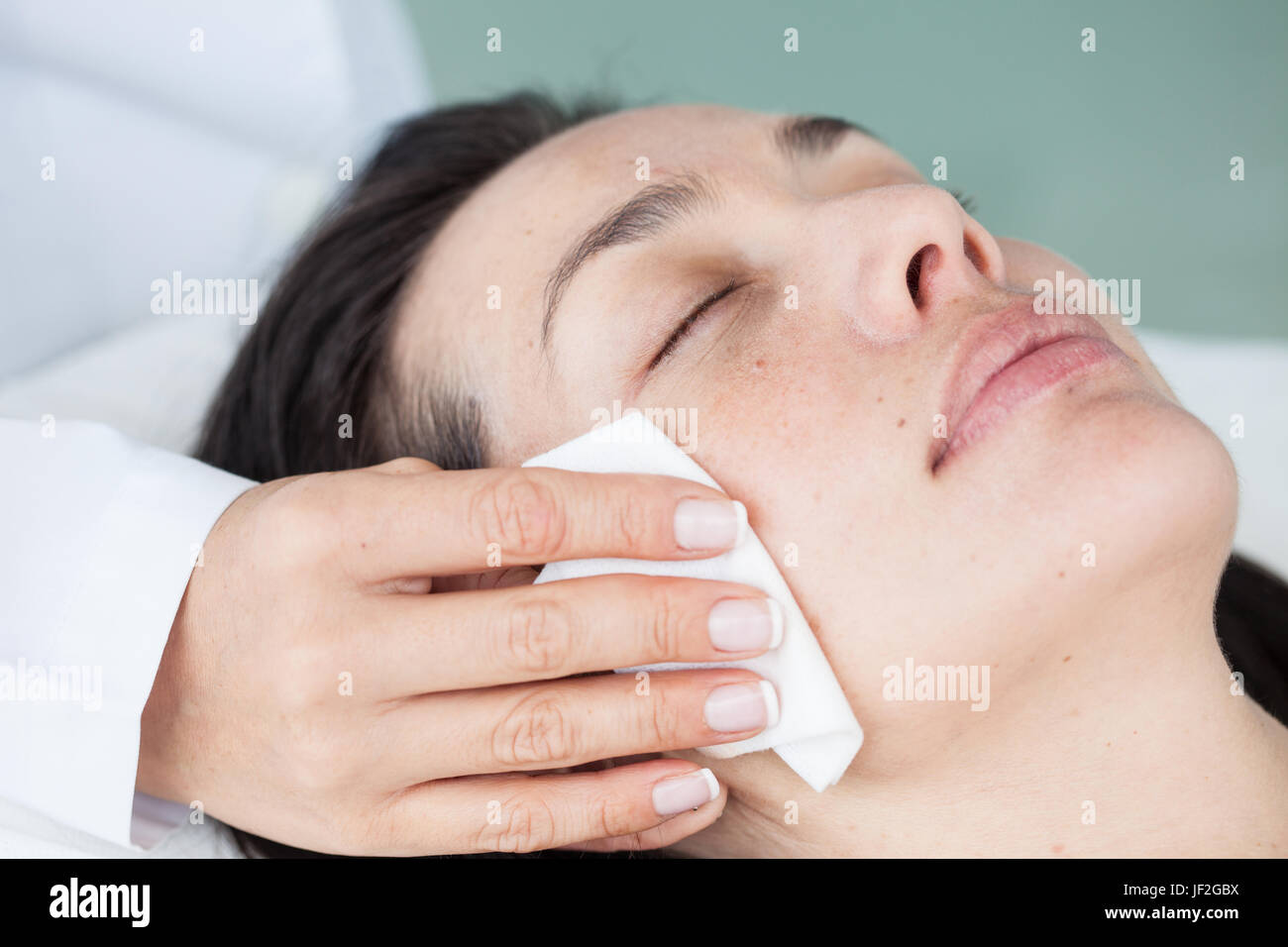 Doctor cleaning a woman patient face Stock Photo - Alamy