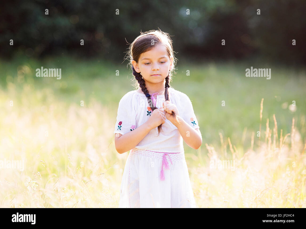 little happy girl with tight braids wearing traditional romanian blouse ...