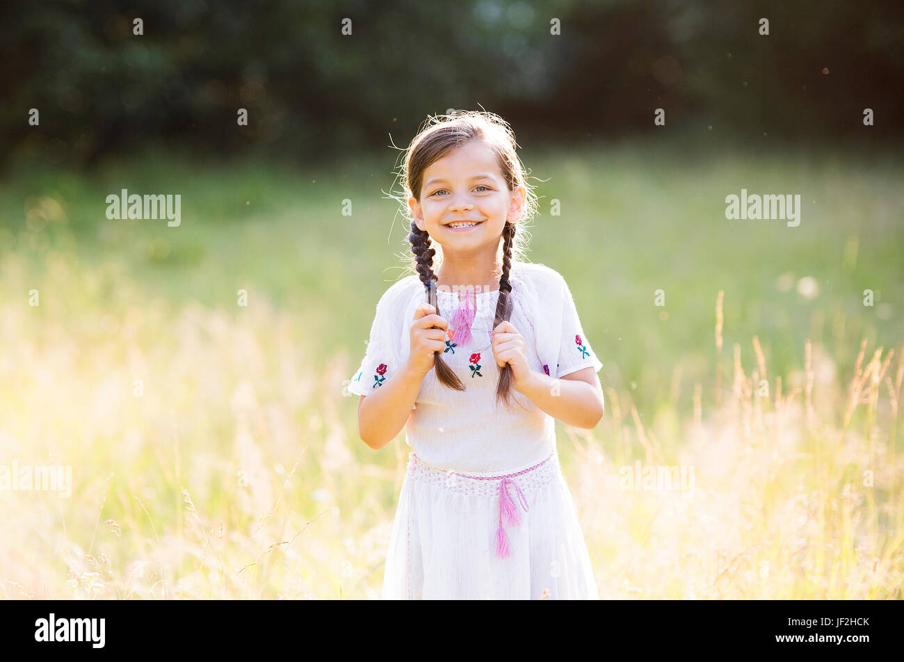 little happy girl with tight braids wearing traditional romanian blouse ...