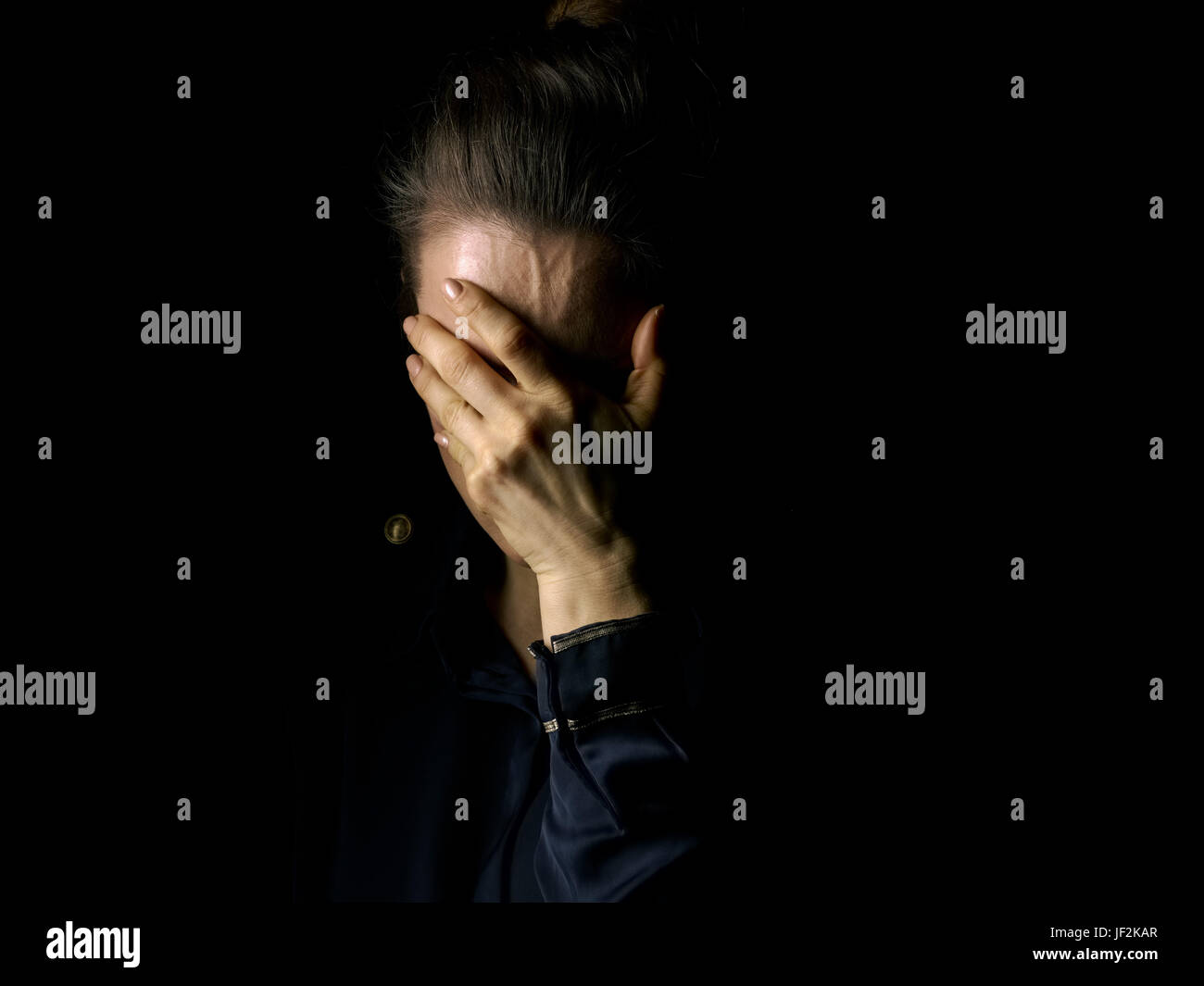 Coming out into the light. Portrait of stressed woman in the dark dress ...