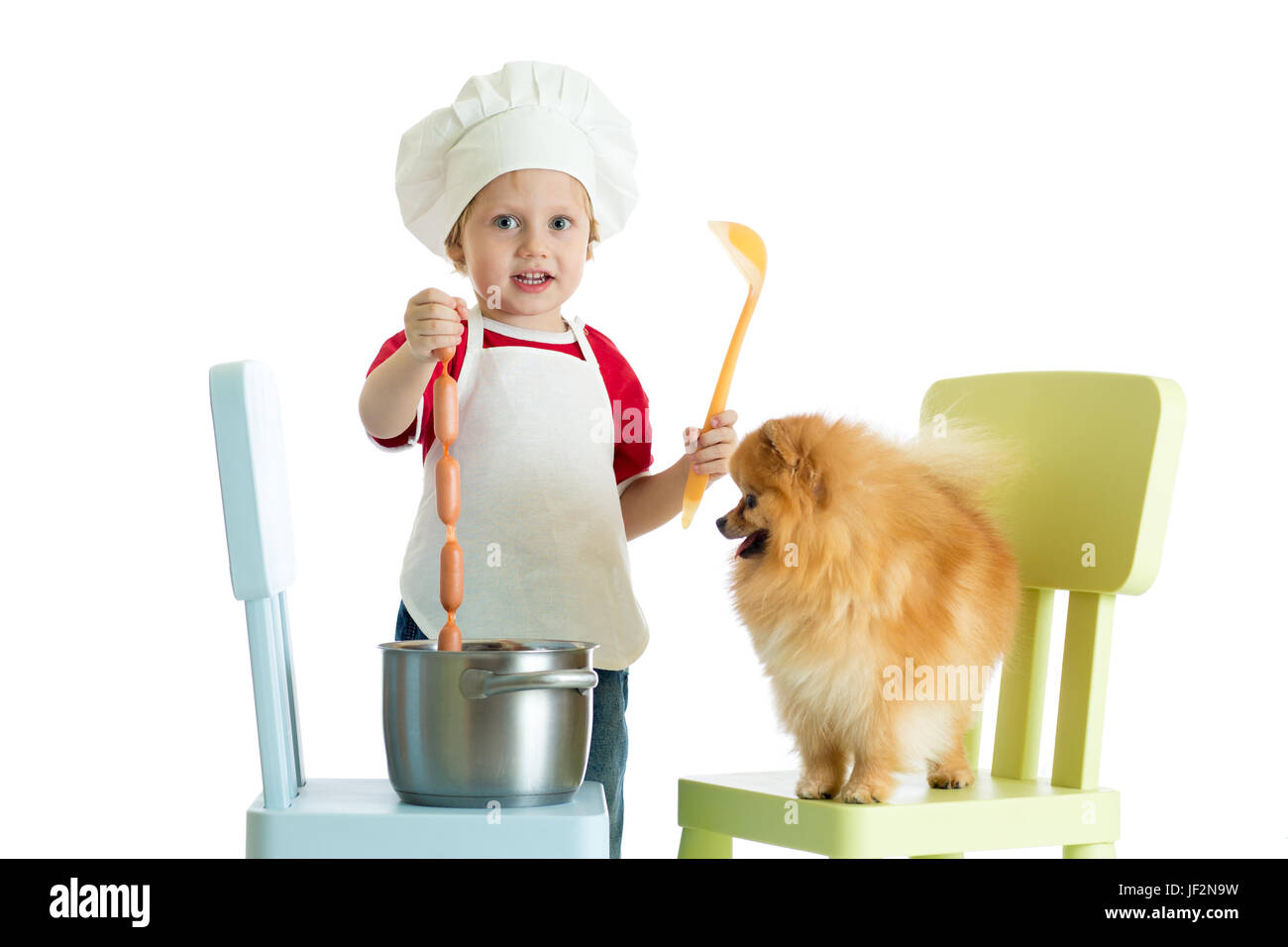 Role-playing game. Kid boy playing chef with dog. Child weared cook ...