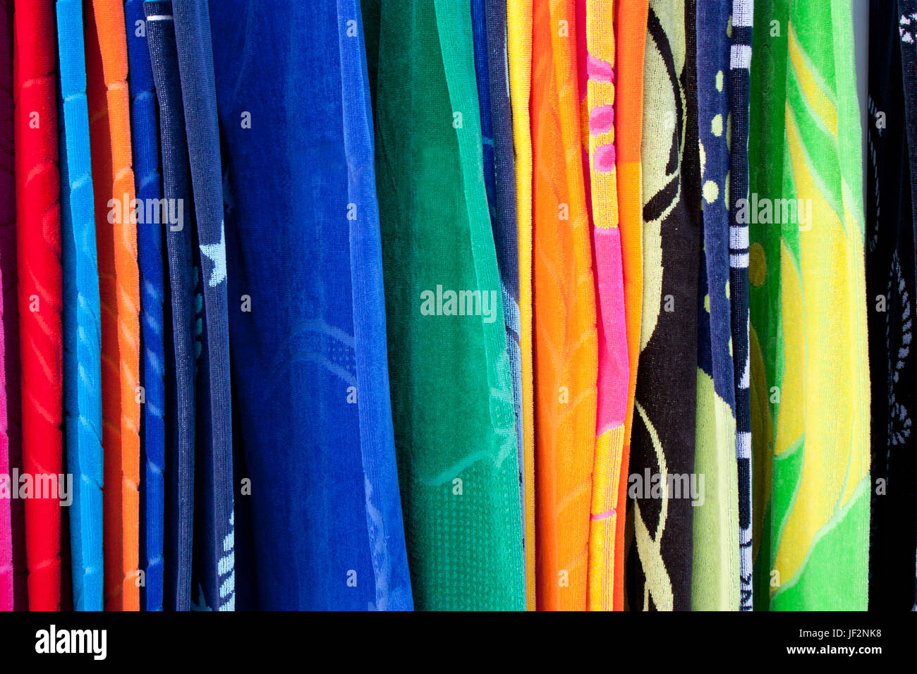 Different colored beach towels hanging on display in a shop, detail ...
