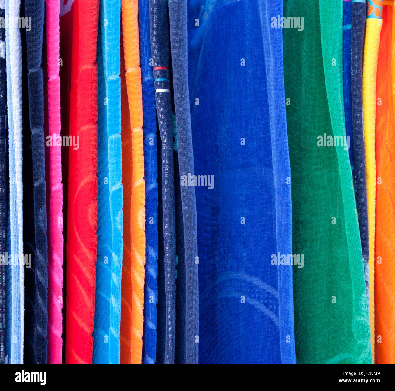 Different colored beach towels hanging on display in a shop, detail ...