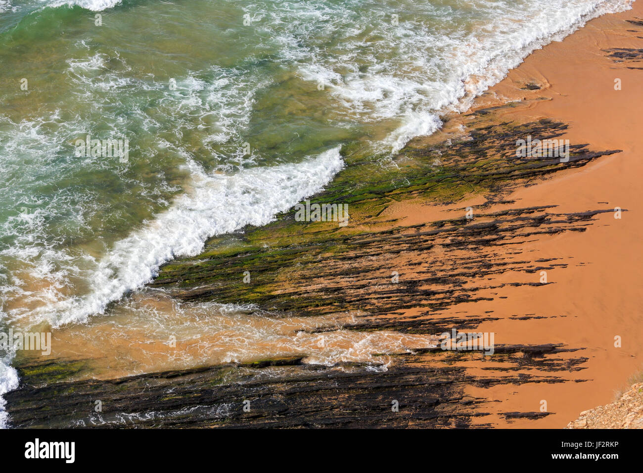 Rock formations on beach and surf wave Stock Photo - Alamy