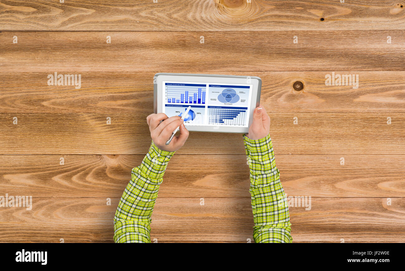 Top view of girl hands using tablet pc with diagrams and graphs on ...