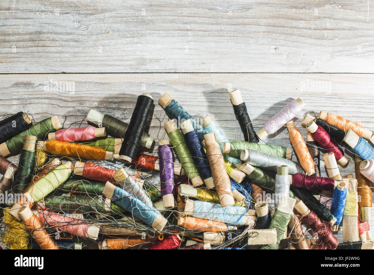 Spools of thread on white wood Stock Photo - Alamy