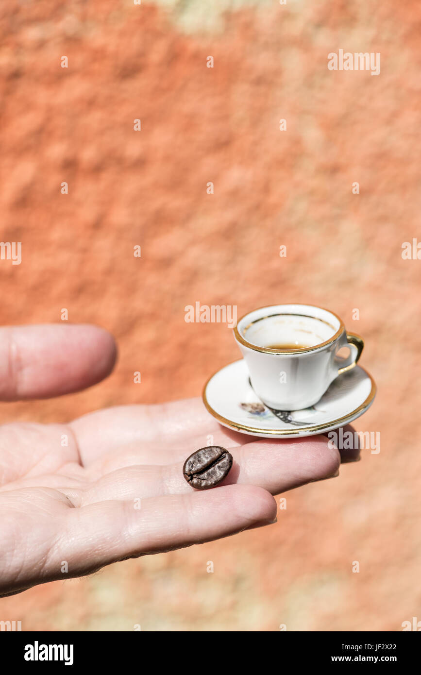 Hand hold small cup of coffee Stock Photo - Alamy
