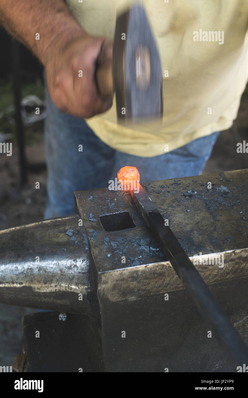 Blacksmith forges iron on anvil Stock Photo - Alamy