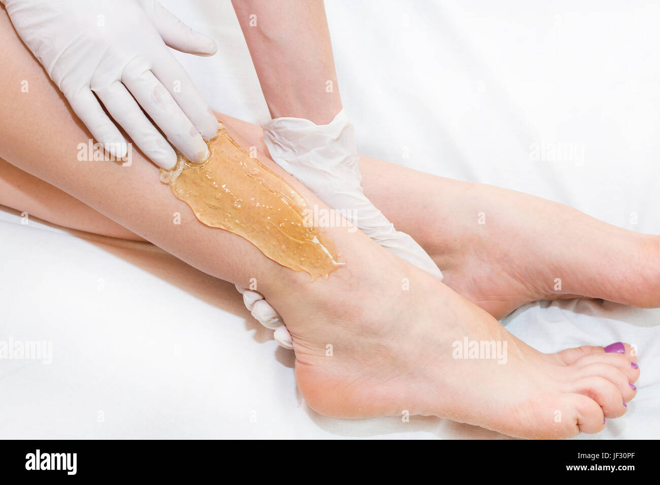 Depilation sugar processes woman passes in a beauty salon Stock Photo ...