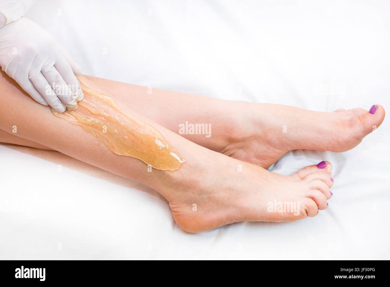 Depilation sugar processes woman passes in a beauty salon Stock Photo ...