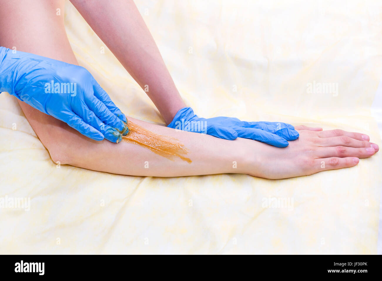 Depilation sugar processes woman passes in a beauty salon Stock Photo ...