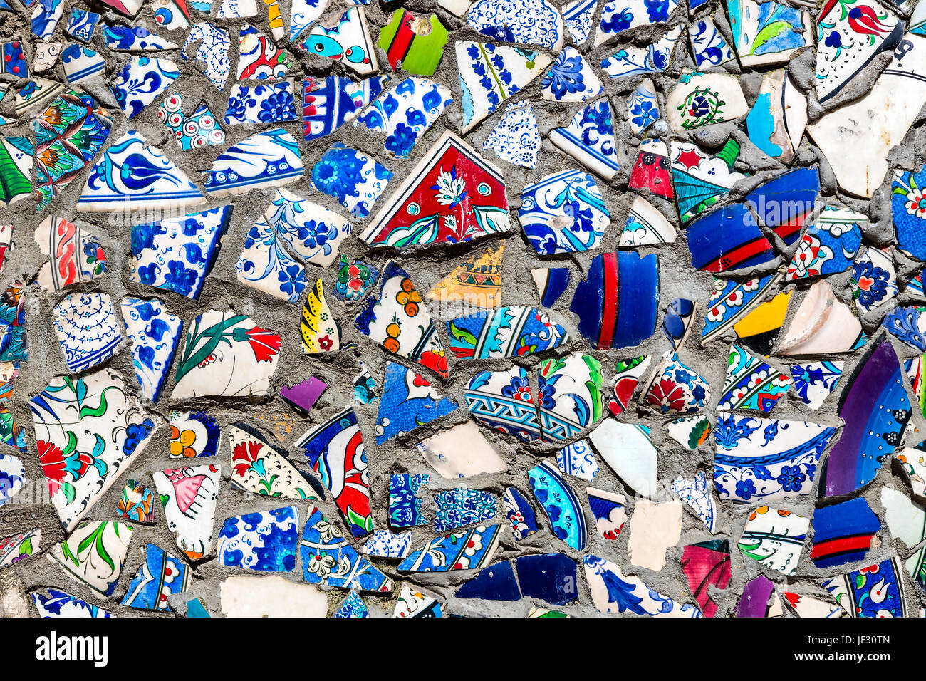 Wall with broken ceramic plates colored fragments Stock Photo - Alamy
