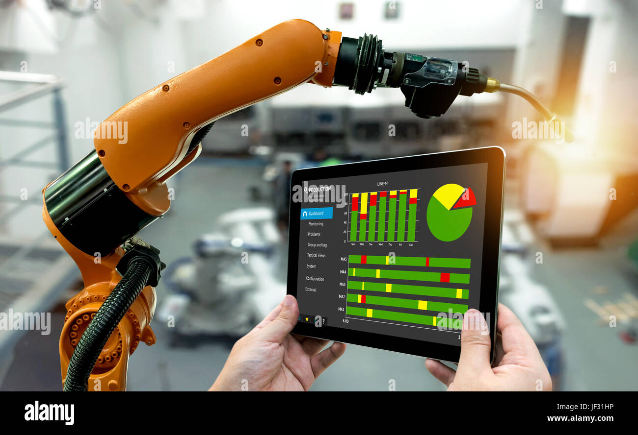 Engineer manager hand using tablet, heavy automation robot arm machine ...