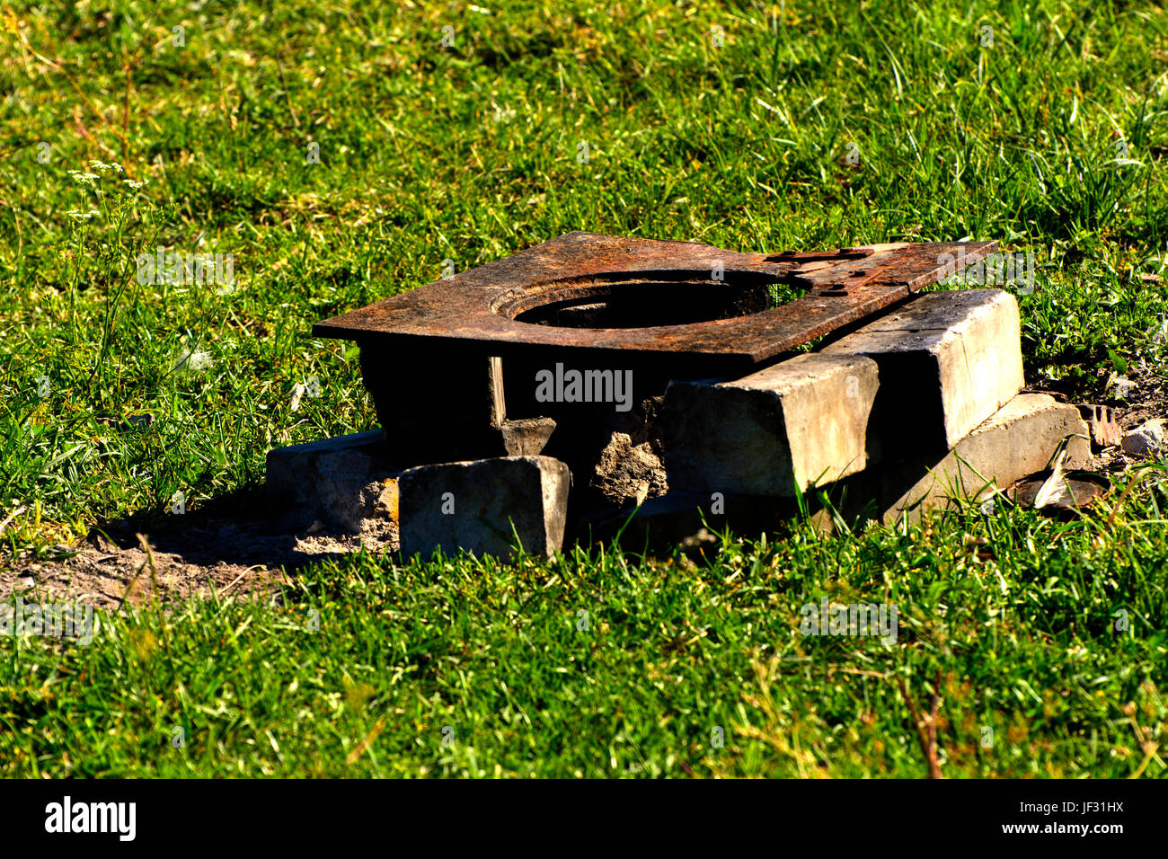 The old rusty stove stands on the bricks in the field. Homemade oven ...
