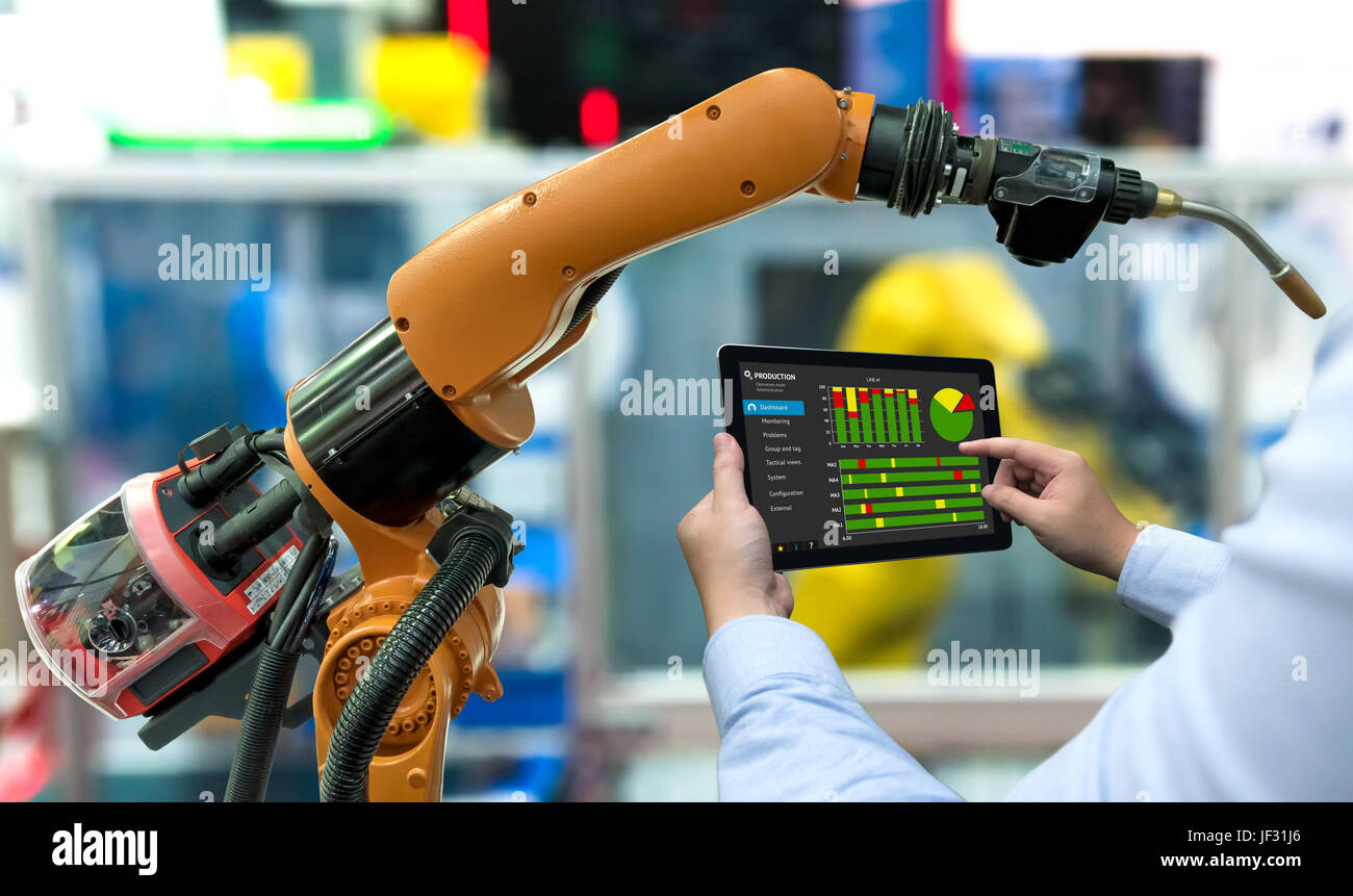 Engineer manager hand using tablet, heavy automation robot arm machine ...