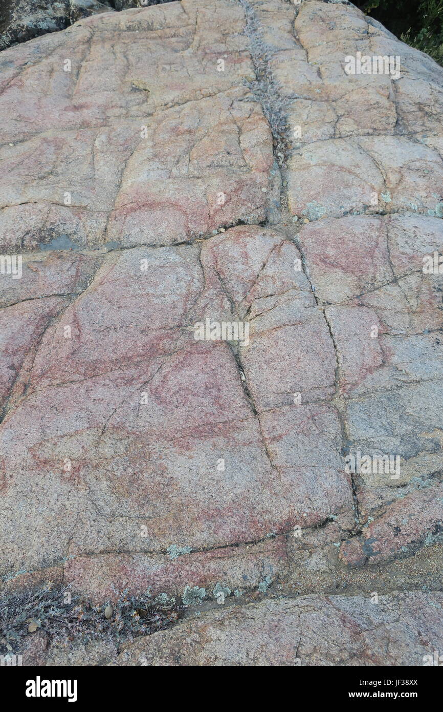 Large flat boulder with reddish tinge and crisscrossing grooves and ...